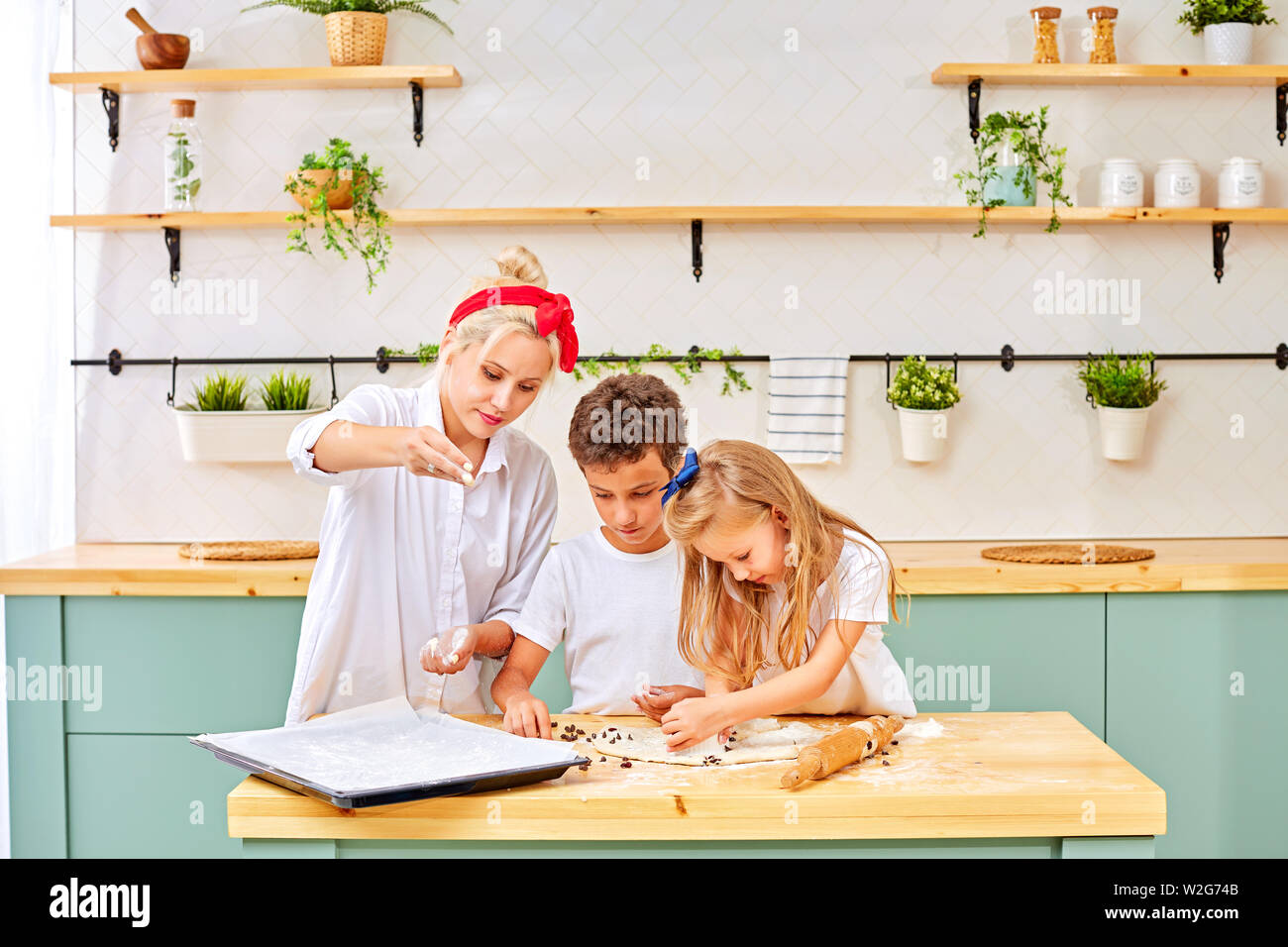 mother sprinkles flour over the ground, children of the fun are ...