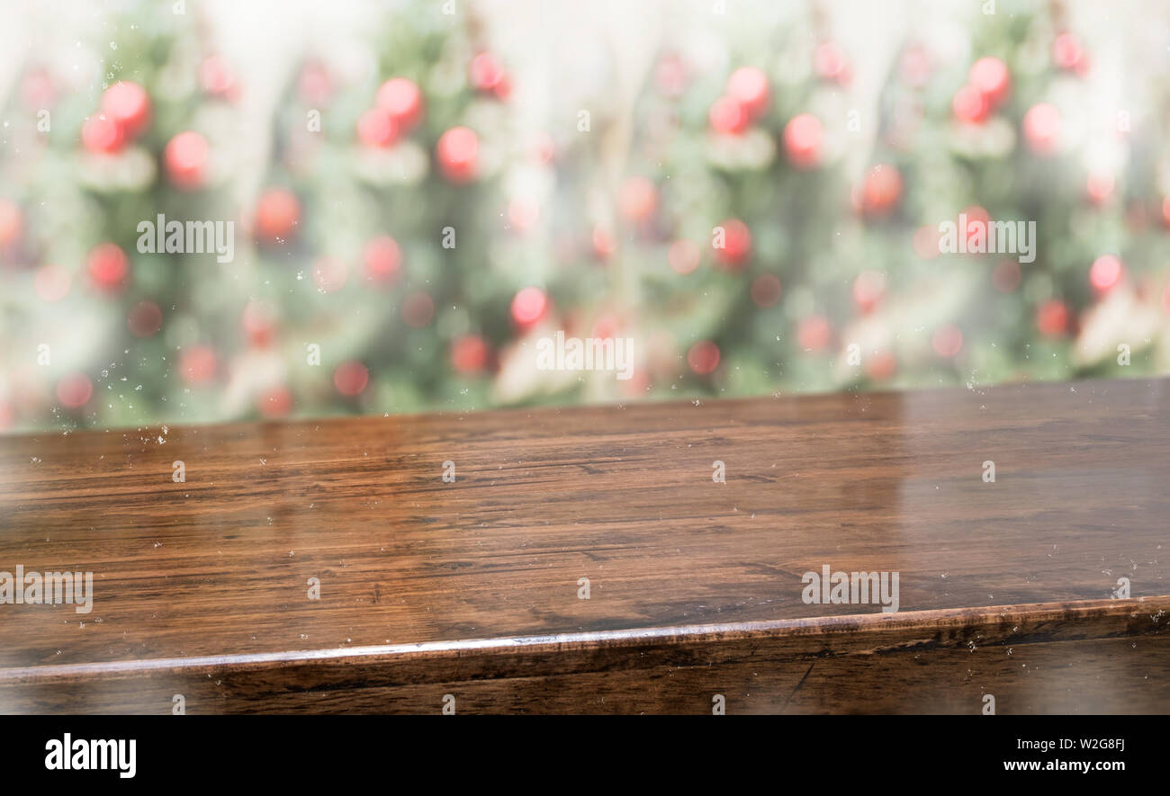 wooden table top with abstract blur christmas tree red decor ball and ...