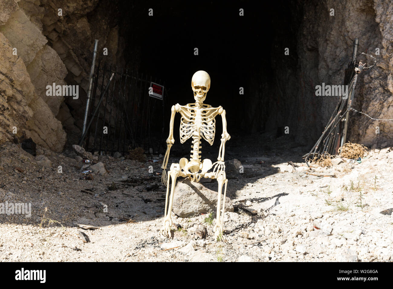Skeleton in the mouth of a dark hole in the ground Stock Photo - Alamy
