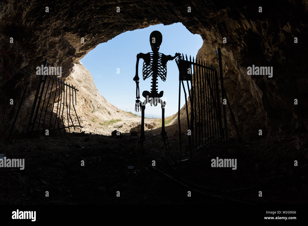 Skeleton silhouette in the mouth of a gated mine stay out stay alive ...