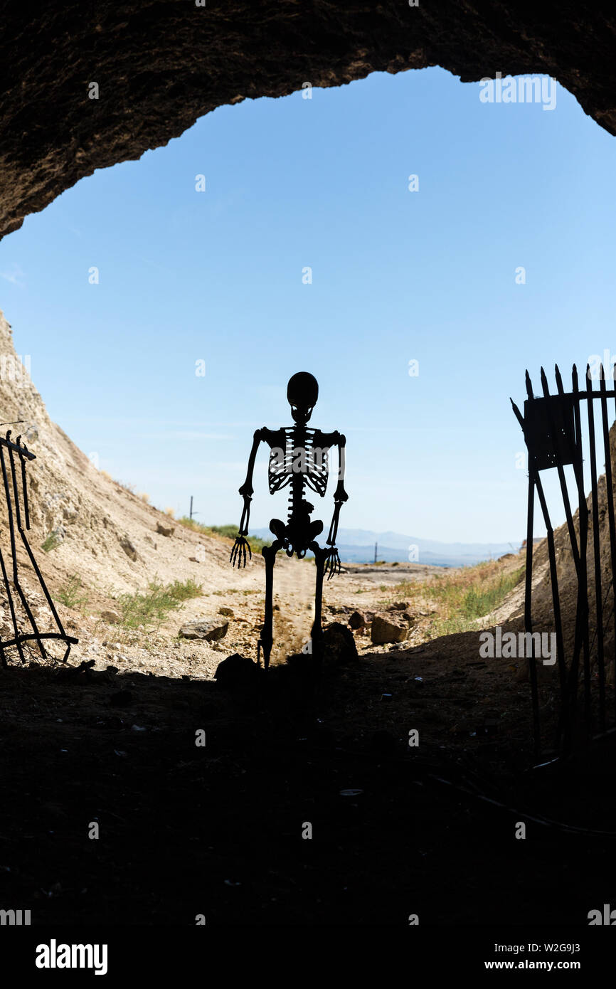 Skeleton silhouette in the mouth of a gated mine stay out stay alive ...