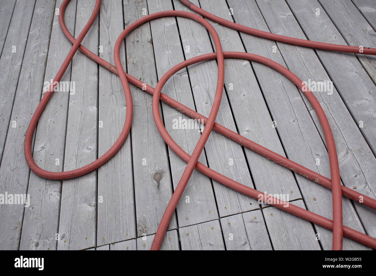 Red hose on cedar deck Stock Photo - Alamy