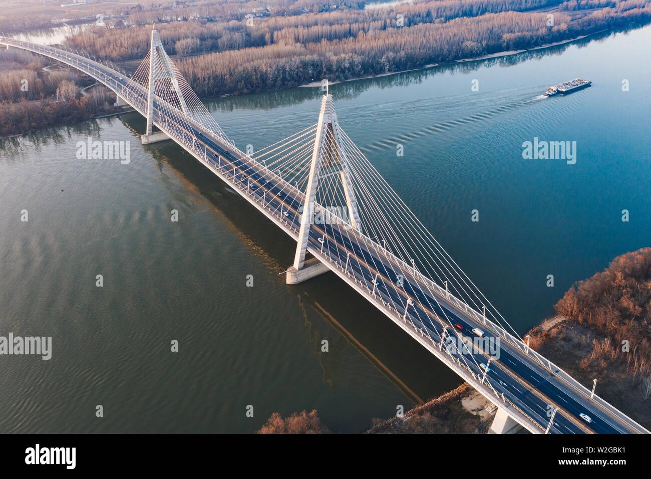 Aerial beautiful shot of a suspension bridge over a large river with a ...