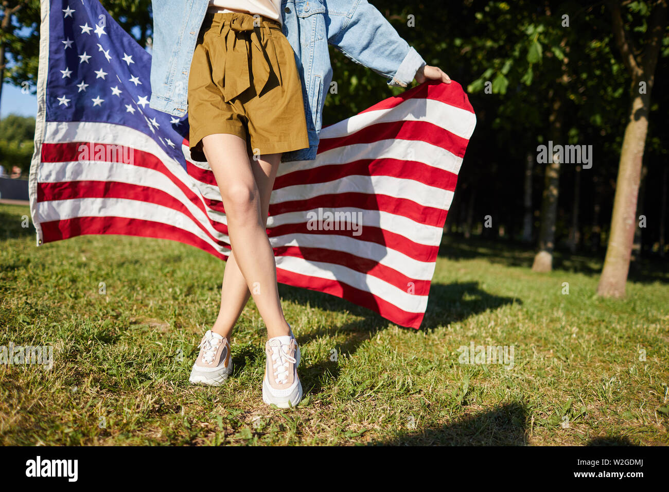 Long legs of unrecognizable woman in beige wide shorts and fashionable ...