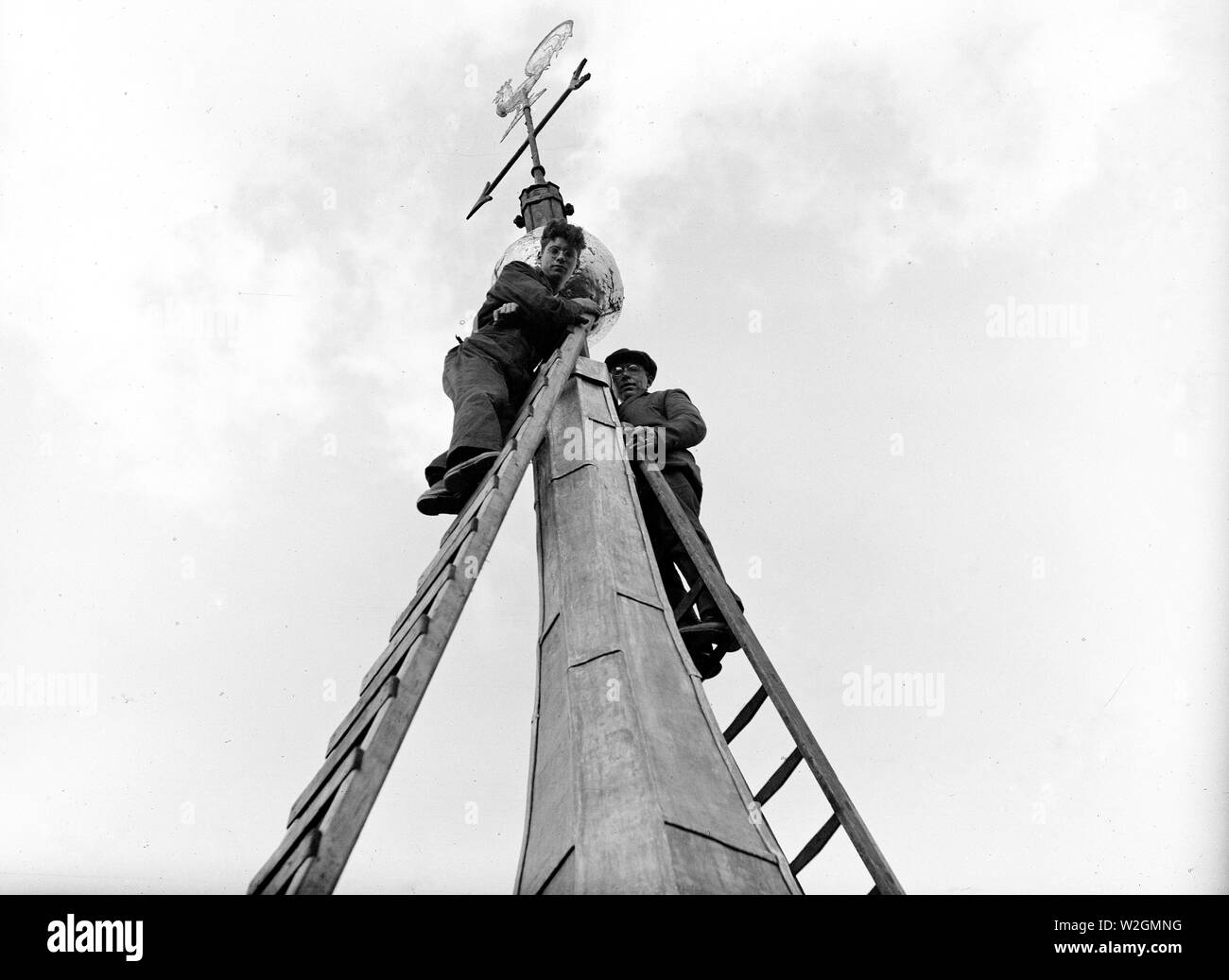 Two men on ladders Black and White Stock Photos & Images - Alamy