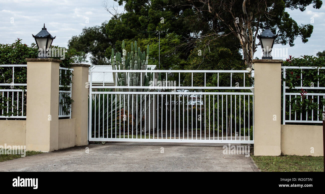 White metal wrought iron driveway property entrance gates set in ...