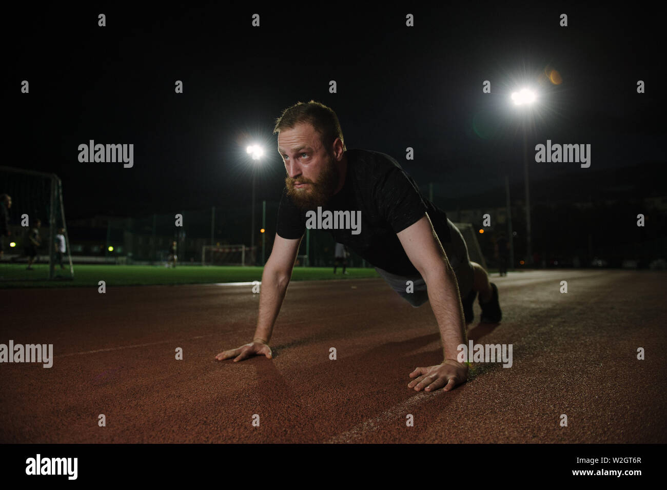 Young athletic bearded man doing push-ups muscular and strong guy ...