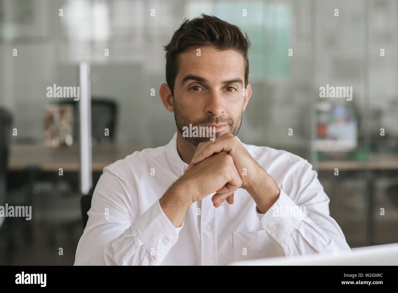 Focused young businessman sitting alone in a modern office Stock Photo ...
