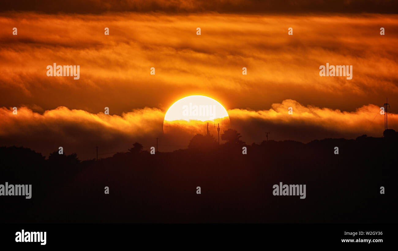 A telephoto color image of the sun setting over Trinidad Head ...