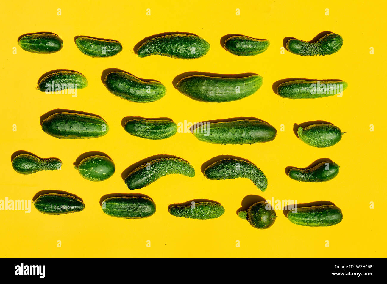 Different sizes forms cucumbers pattern on a light yellow background ...