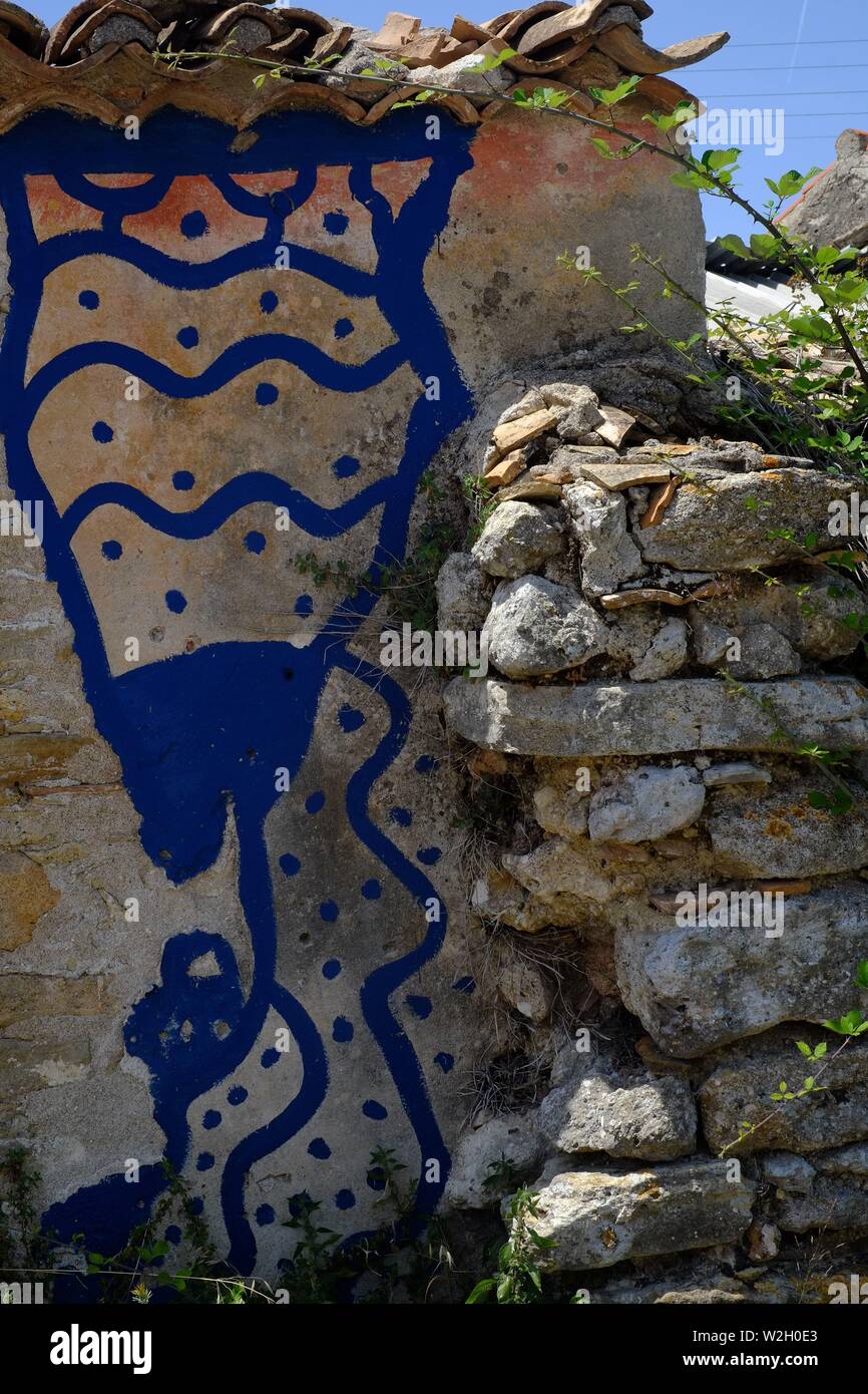 Blue painted graffiti on a section of wall attached to a new house in ...