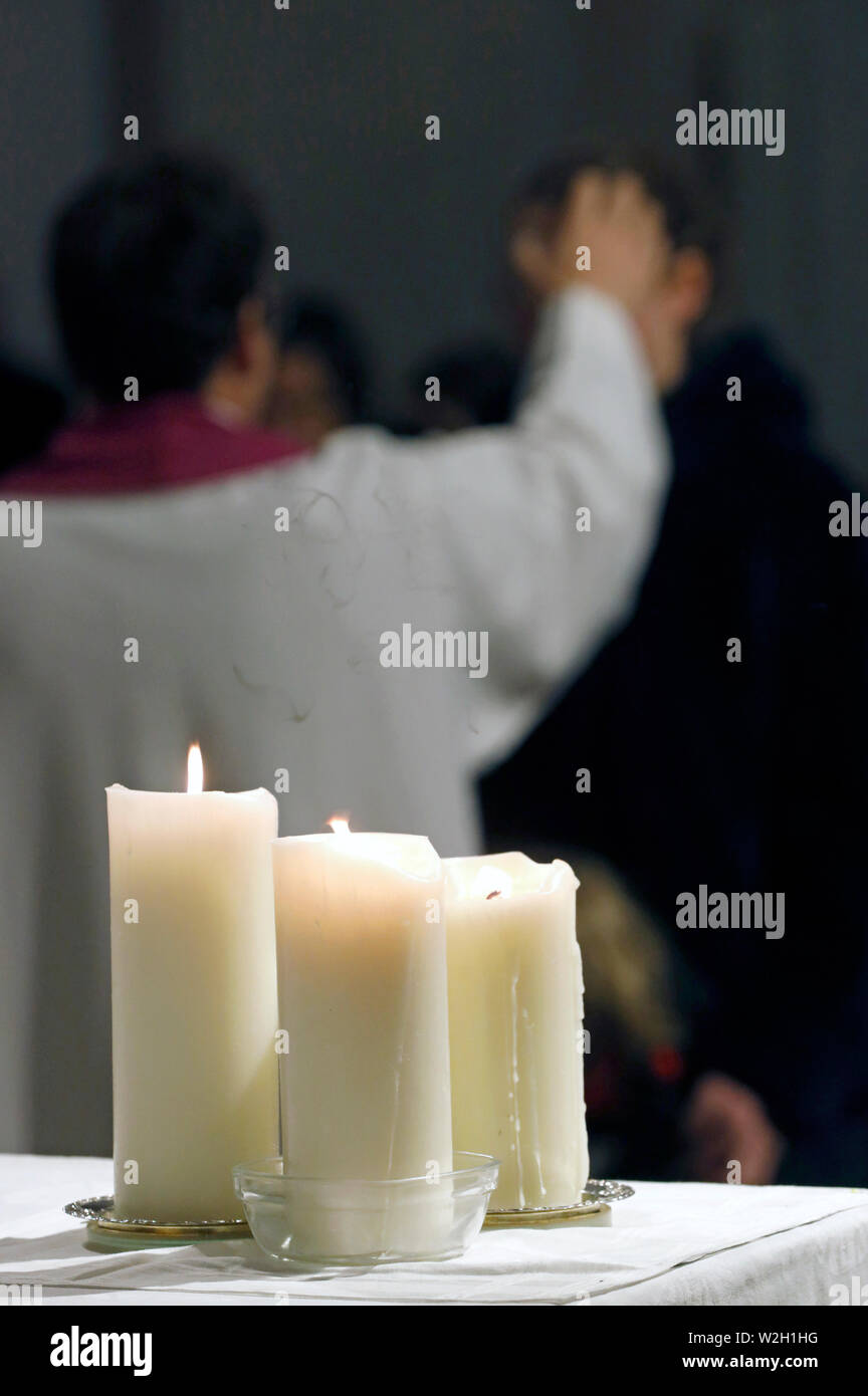 Ash Wednesday. A priest marks a cross of ashes on a worshipper's ...