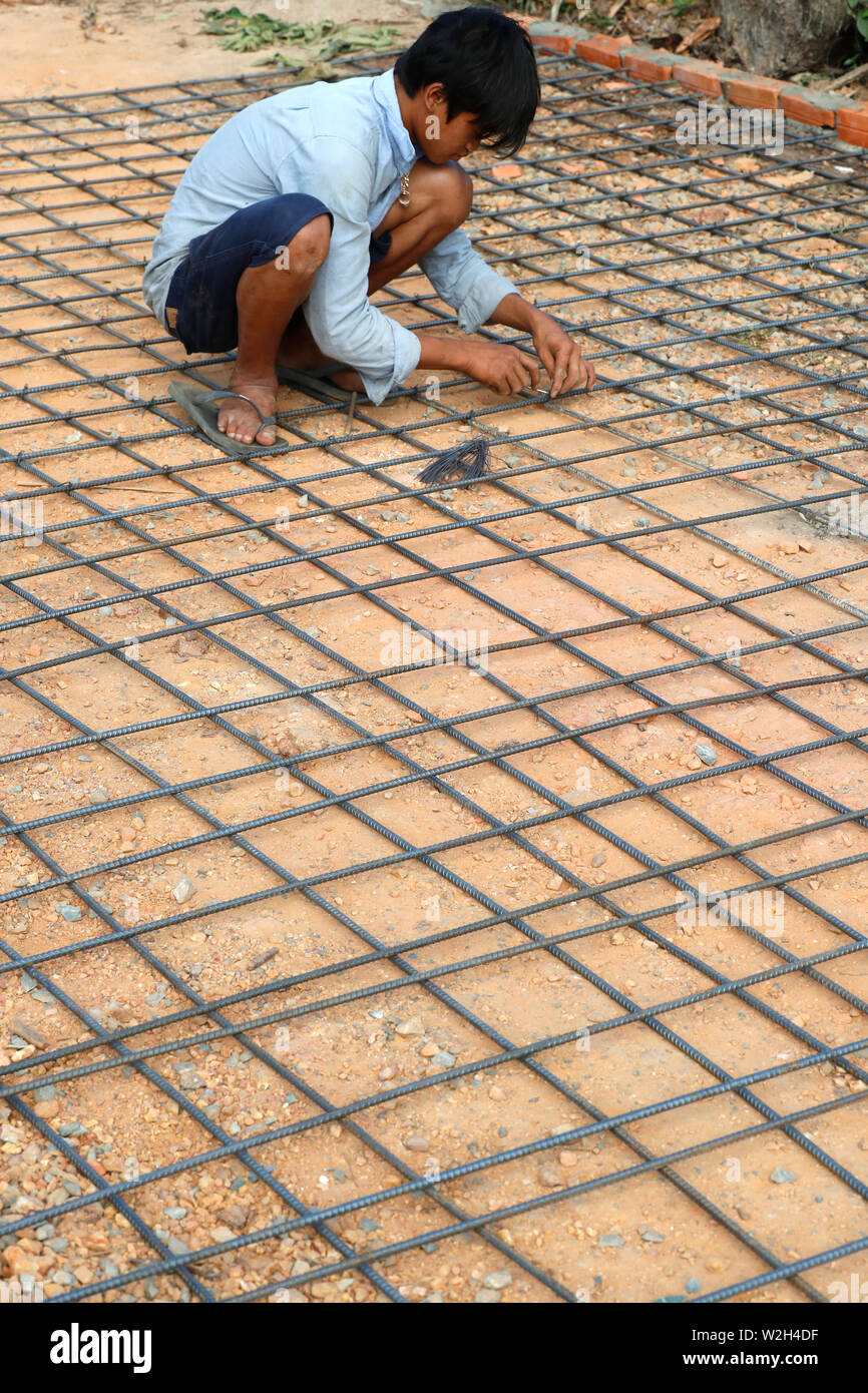 Worker at construction site. Steel rebar for concrete reinforcing ...