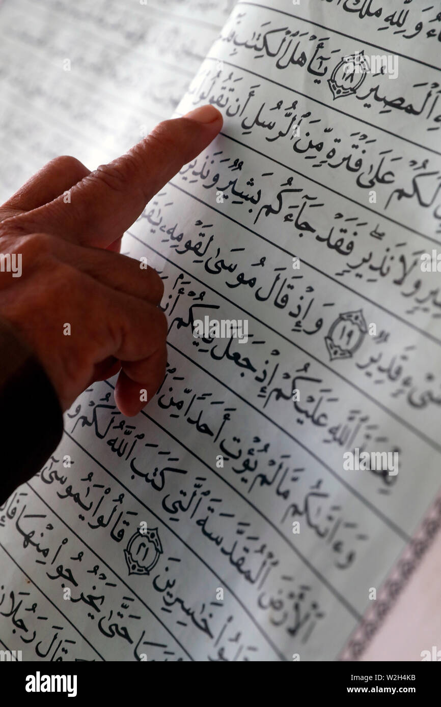 Masjid Nurul Naim mosque. Imam reading the Quran. Close-up. Arabic ...