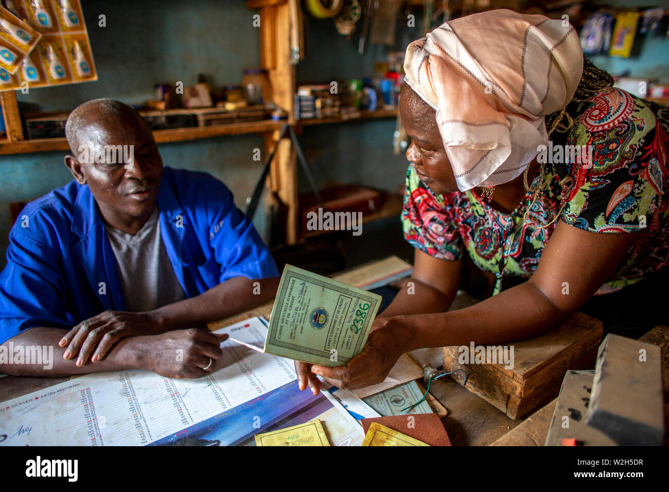 Microfinance client in his shop with a microfinance institution ...