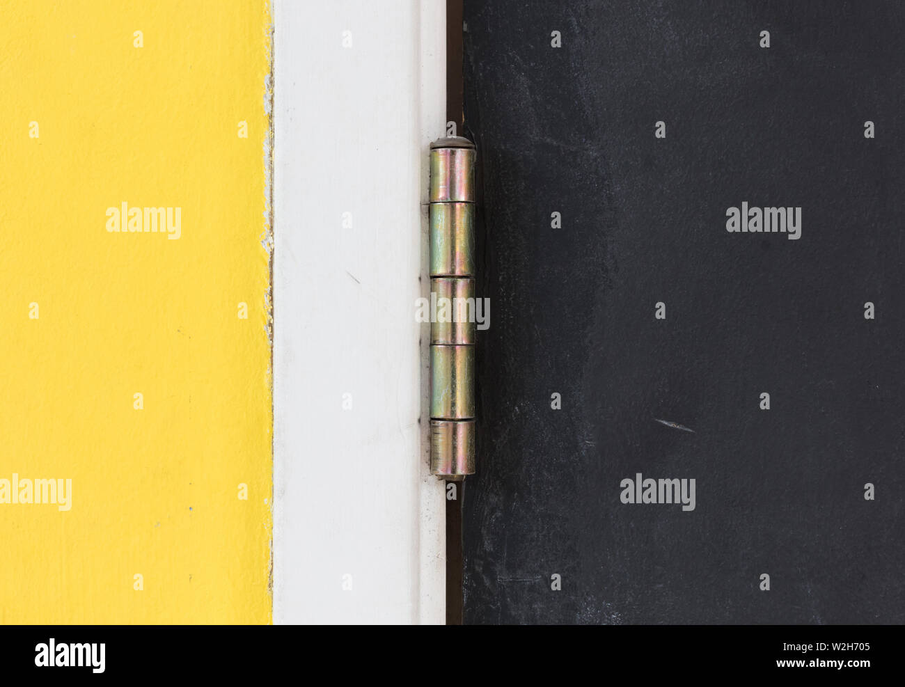 Door hinge, dark door, yellow wall, metal hinge in the middle Stock ...