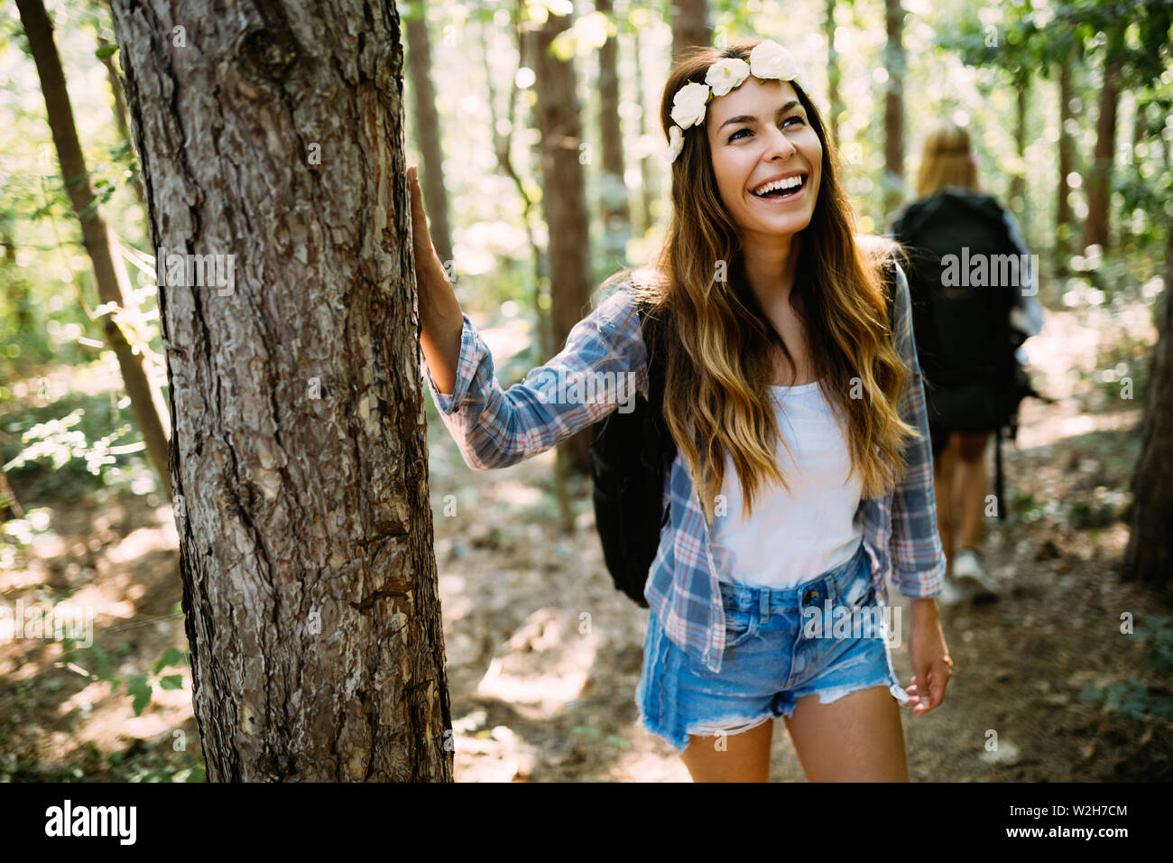 Happy woman with friends hiking in the forest Stock Photo - Alamy