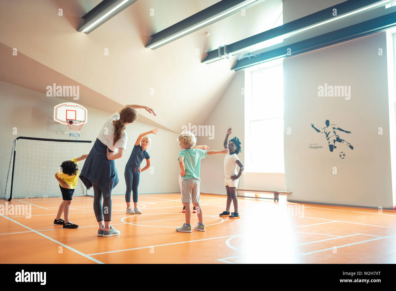 Sports teacher showing exercises to her pupils Stock Photo - Alamy