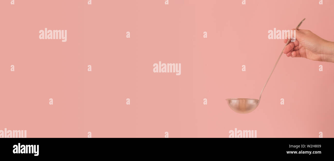 Hand with ladle on pink background with copy space Stock Photo - Alamy