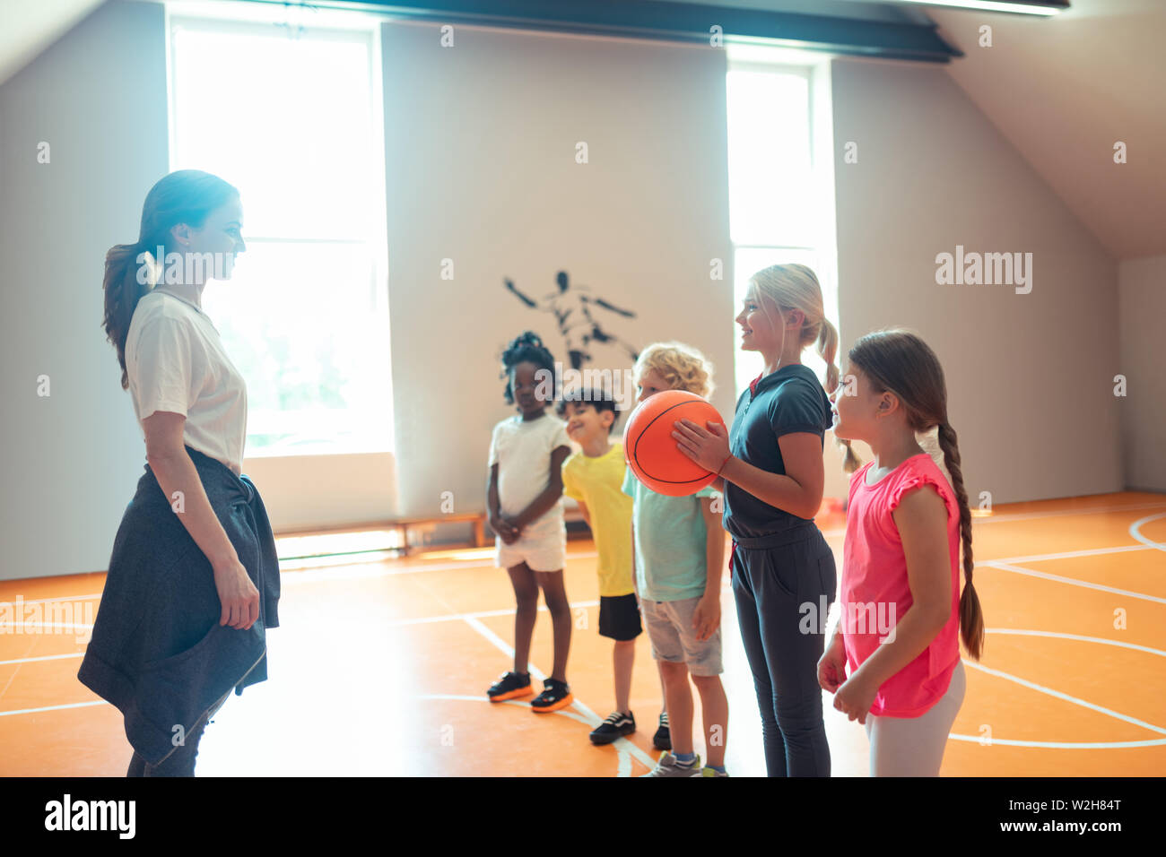 School children playing ball with their sports teacher Stock Photo - Alamy