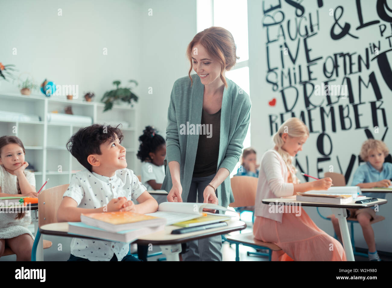 Cheerful pupil smiling to his kind teacher Stock Photo - Alamy