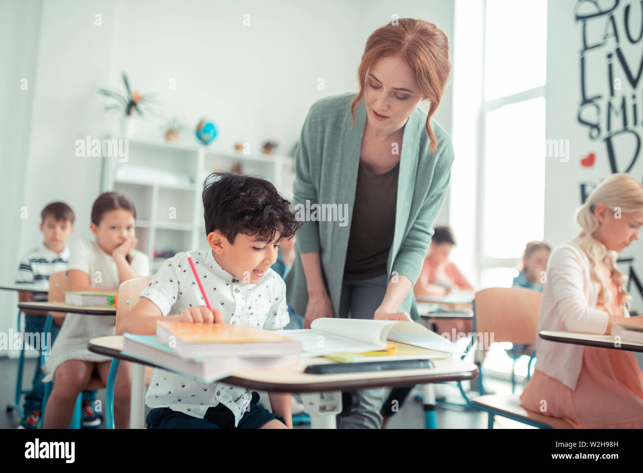 Pupil reading his homework to the teacher Stock Photo - Alamy