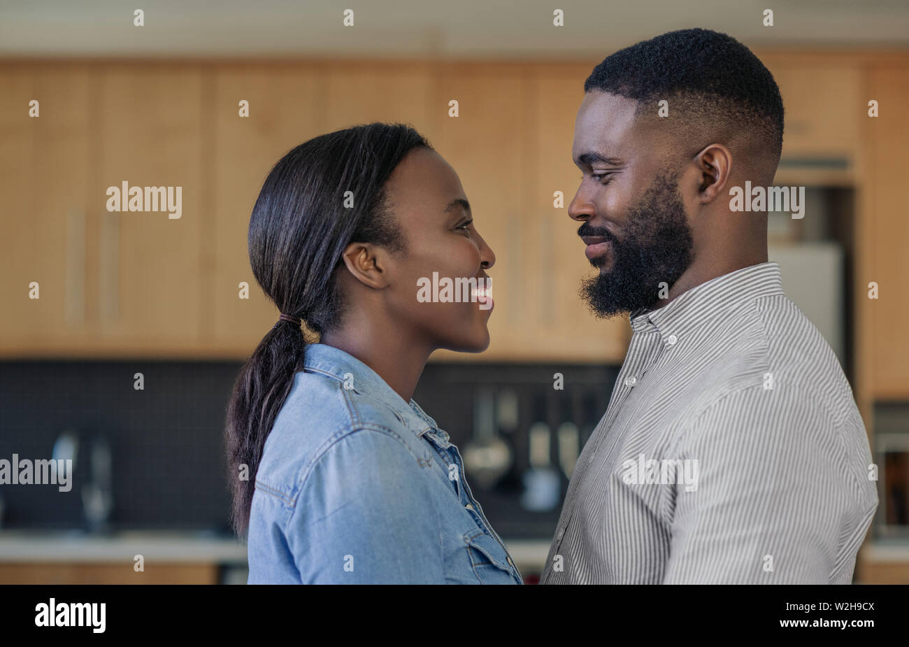 Loving young African American couple looking into each other's eyes ...