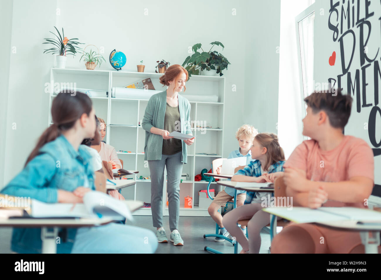 Teacher giving pupils sheets of paper with the test Stock Photo - Alamy