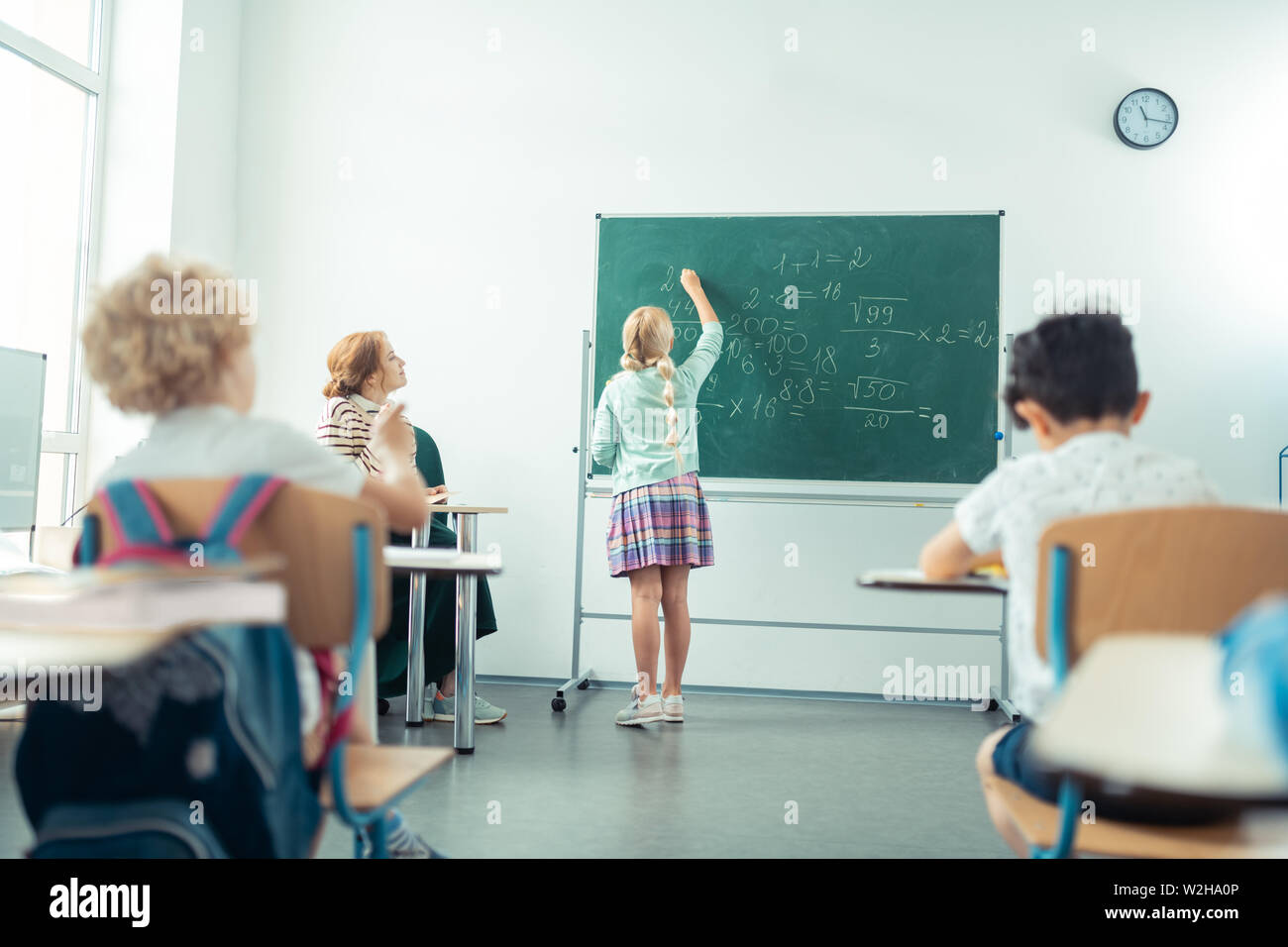 School girl speaking and writing in front of the class Stock Photo - Alamy