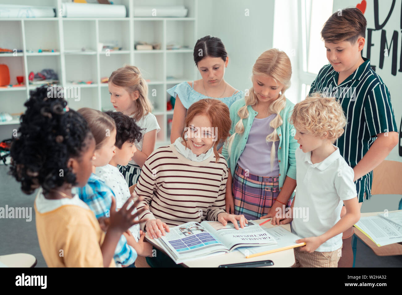 Teacher reading a book to her class Stock Photo - Alamy