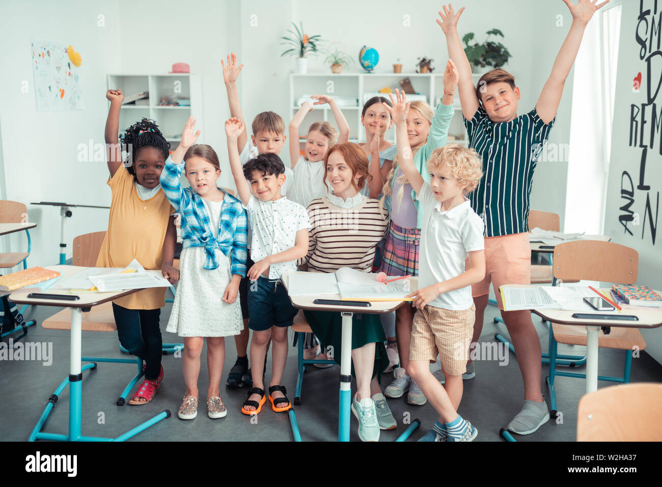 Elementary school class standing around their teacher Stock Photo - Alamy
