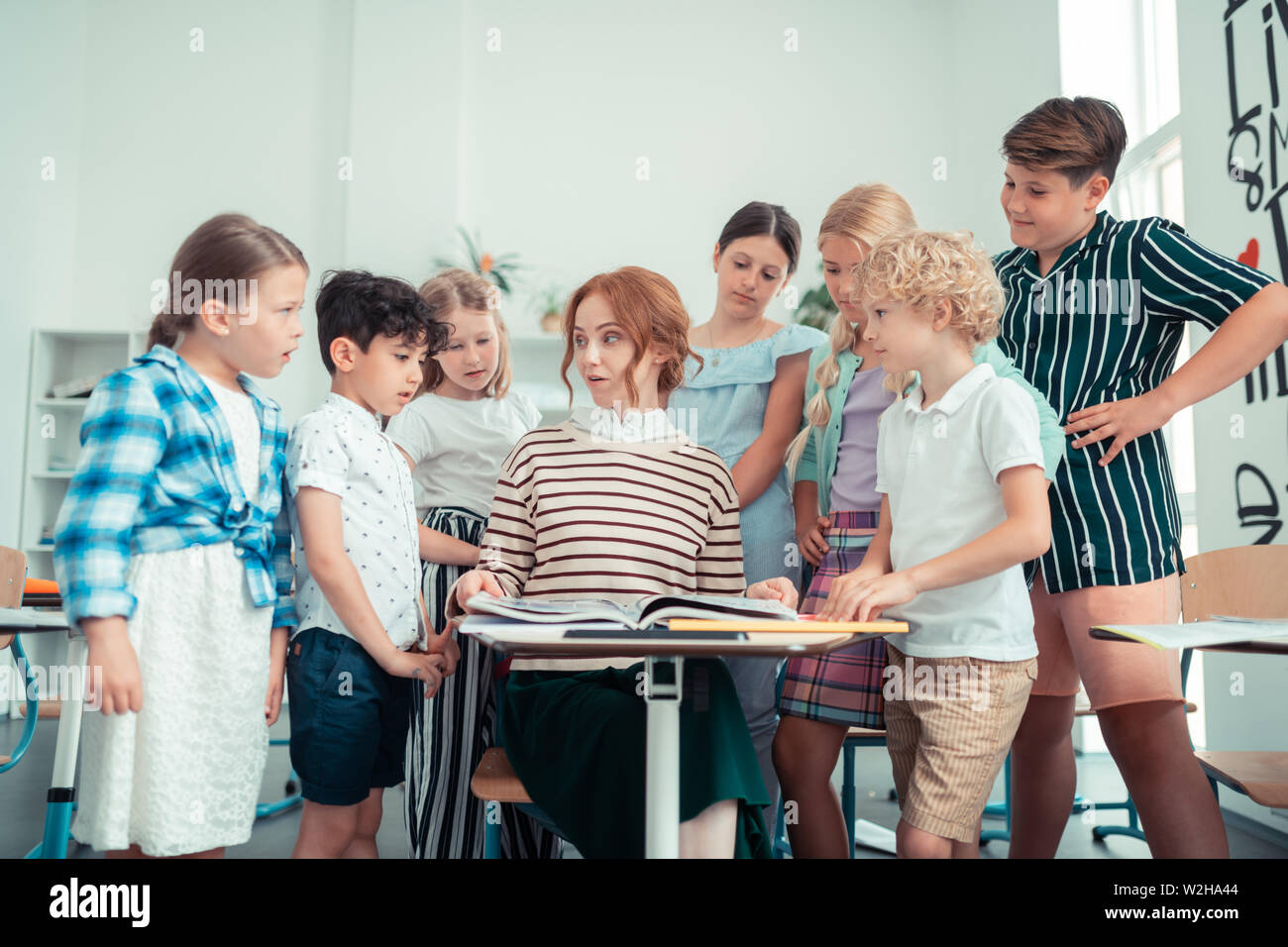 Friendly elementary school teacher talking with her pupils Stock Photo ...