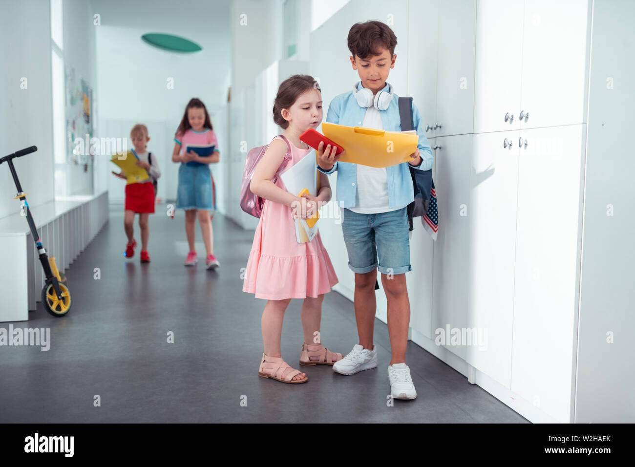 Brother and sister looking at their schedule at school Stock Photo - Alamy