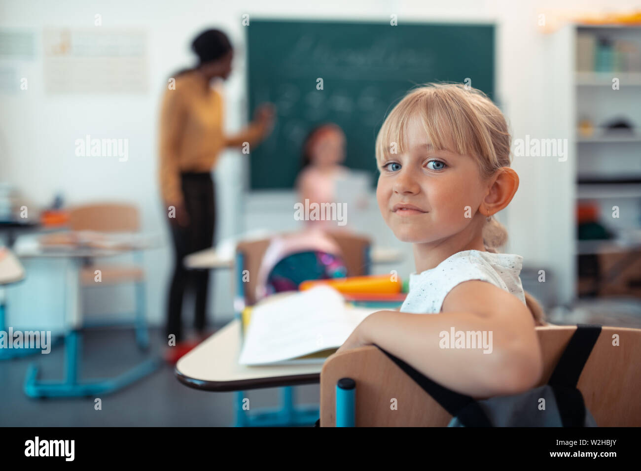 Beautiful blue-eyed girl feeling good while studying at school Stock ...