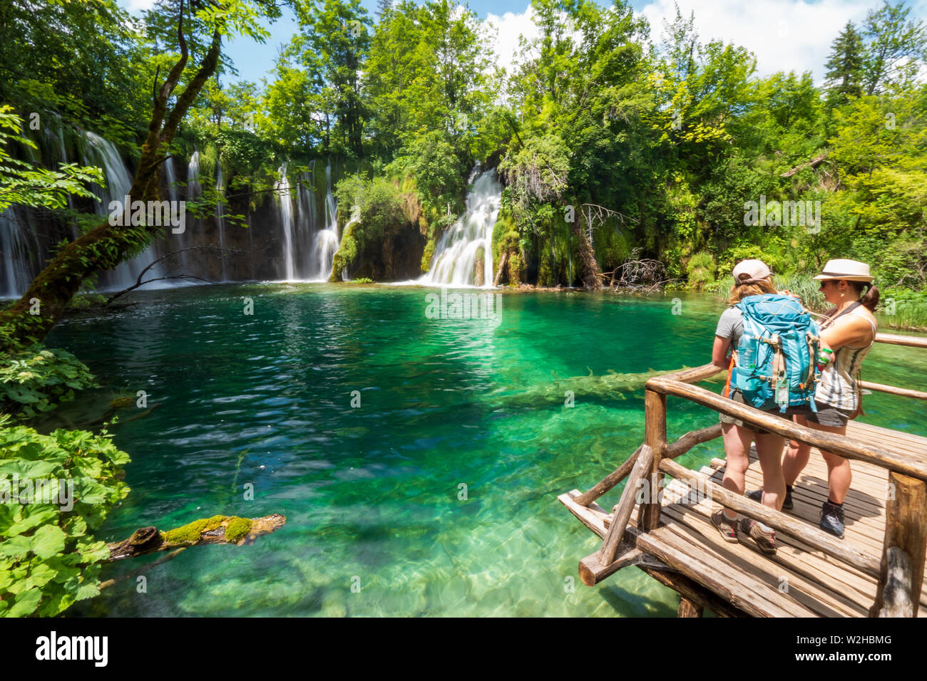 Backpackers on an observation deck with beautiful waterfalls splashing ...