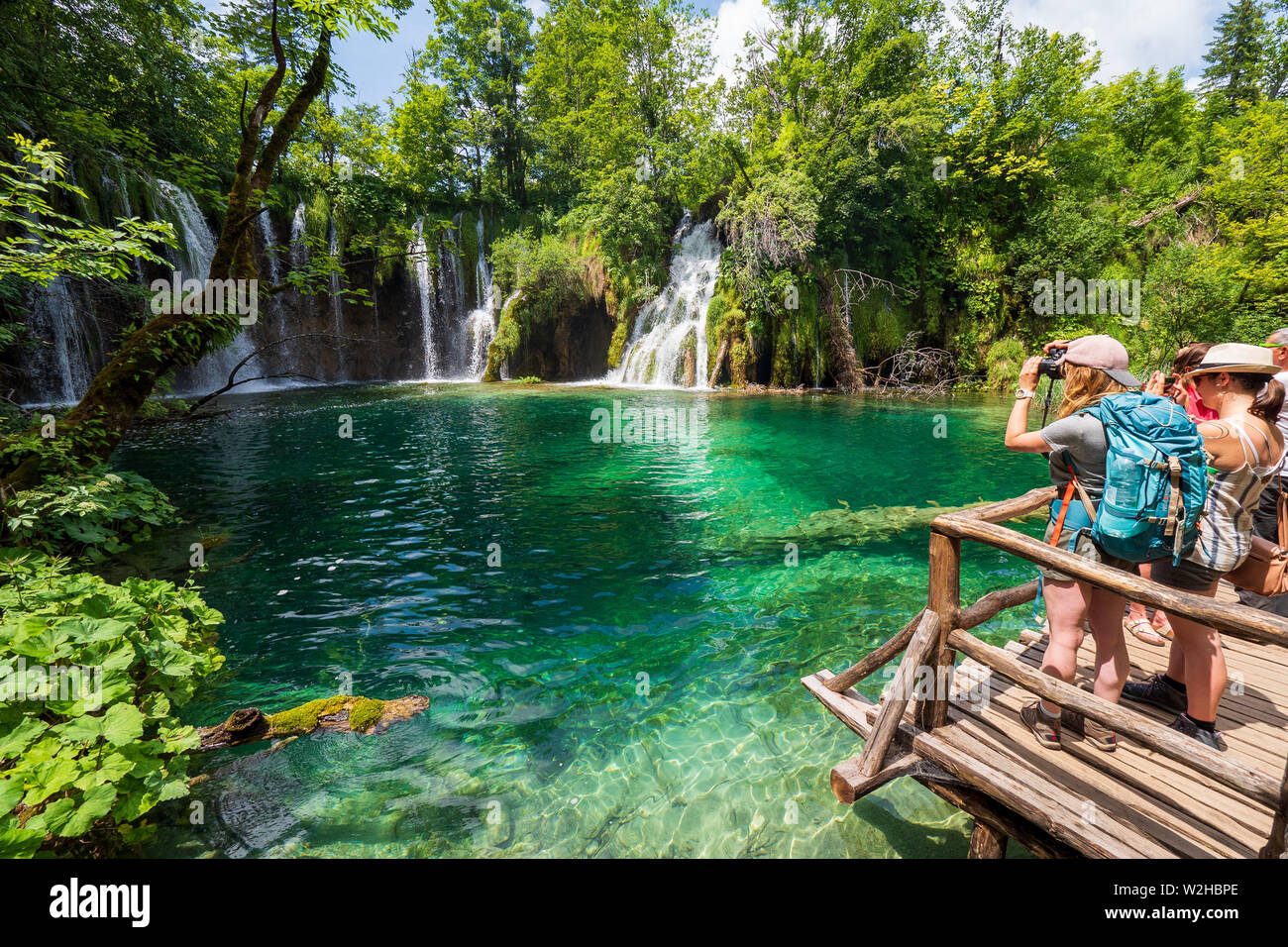 Backpackers on an observation deck with beautiful waterfalls splashing ...