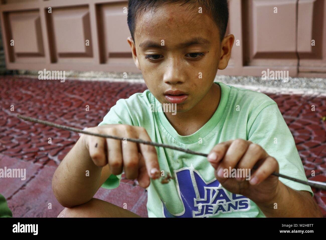 ANTIPOLO CITY, PHILIPPINES – JULY 5, 2019: Young Asian boy watches ...