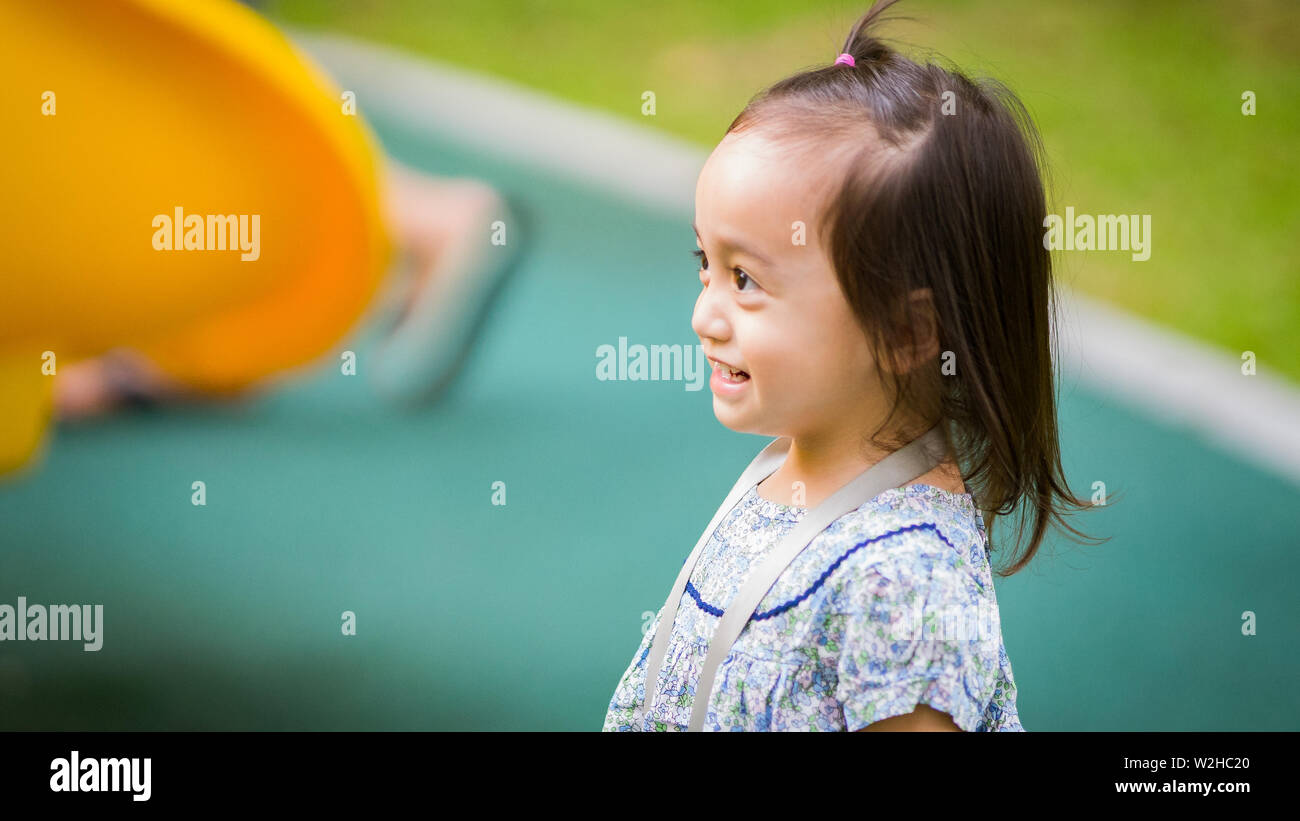 Portrait of asian little girl smiling from side Stock Photo - Alamy