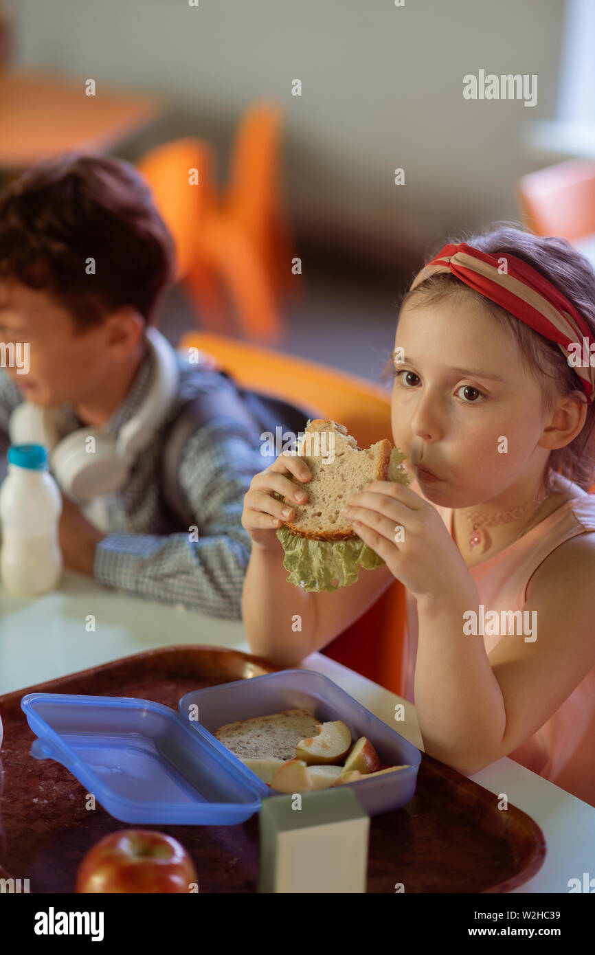 Beautiful cute schoolgirl eating delicious sandwich in canteen Stock ...