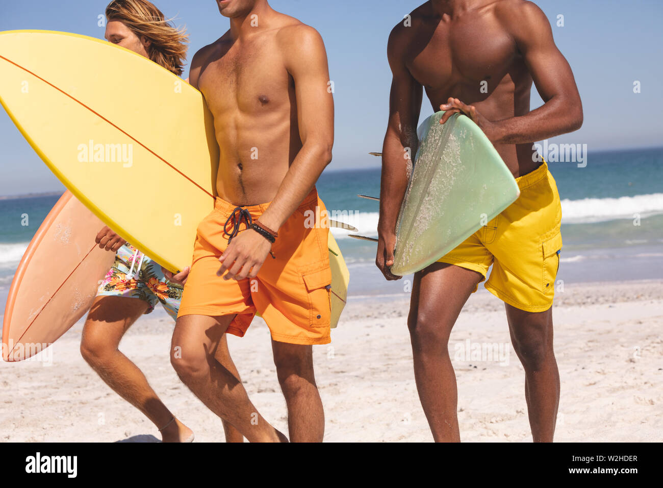 Male friends walking with surfboard on the beach Stock Photo - Alamy