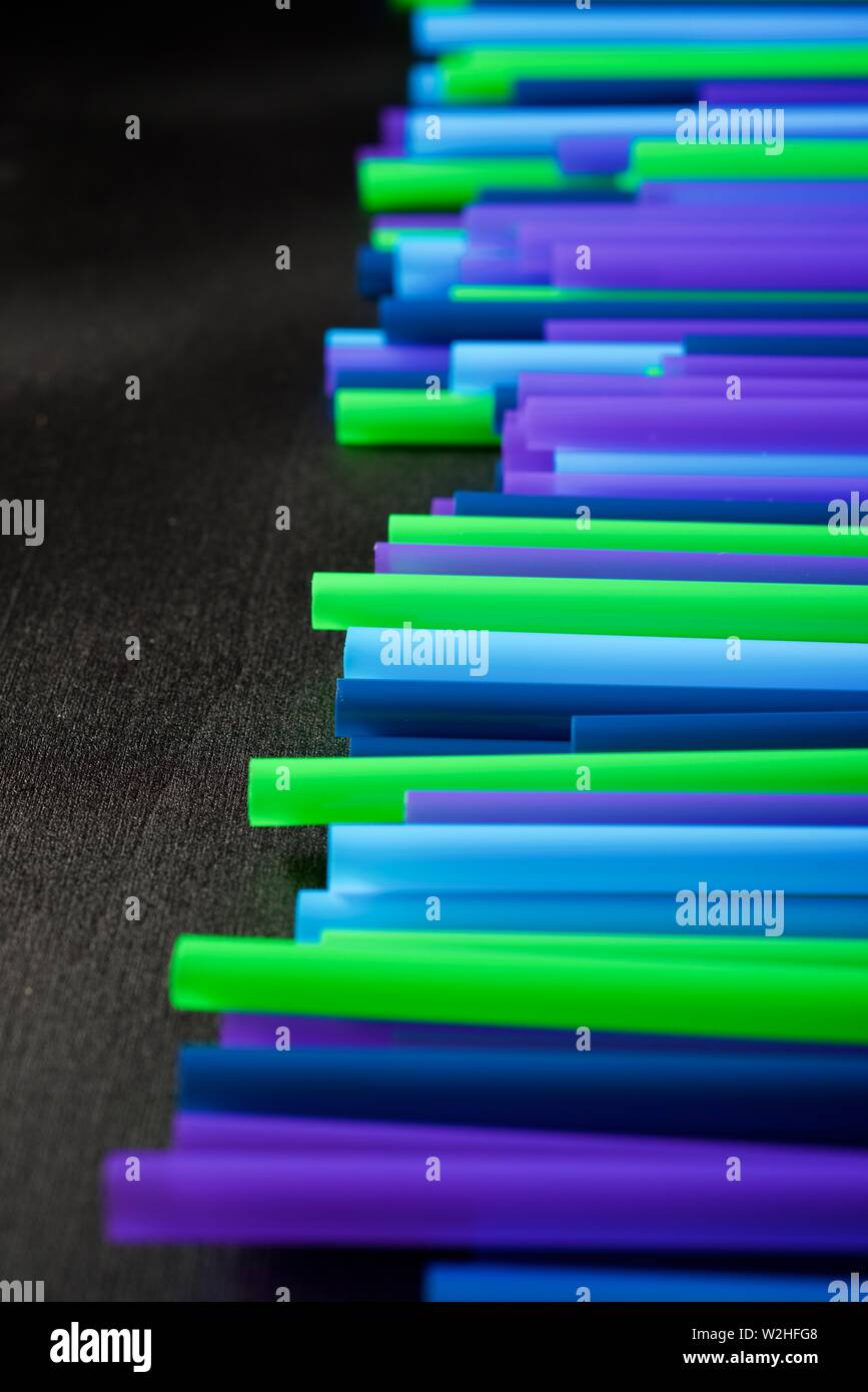 Drinking plastic straws on a black table Stock Photo - Alamy