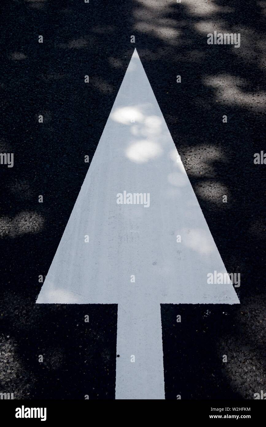 Single arrow directional sign on the floor Stock Photo - Alamy