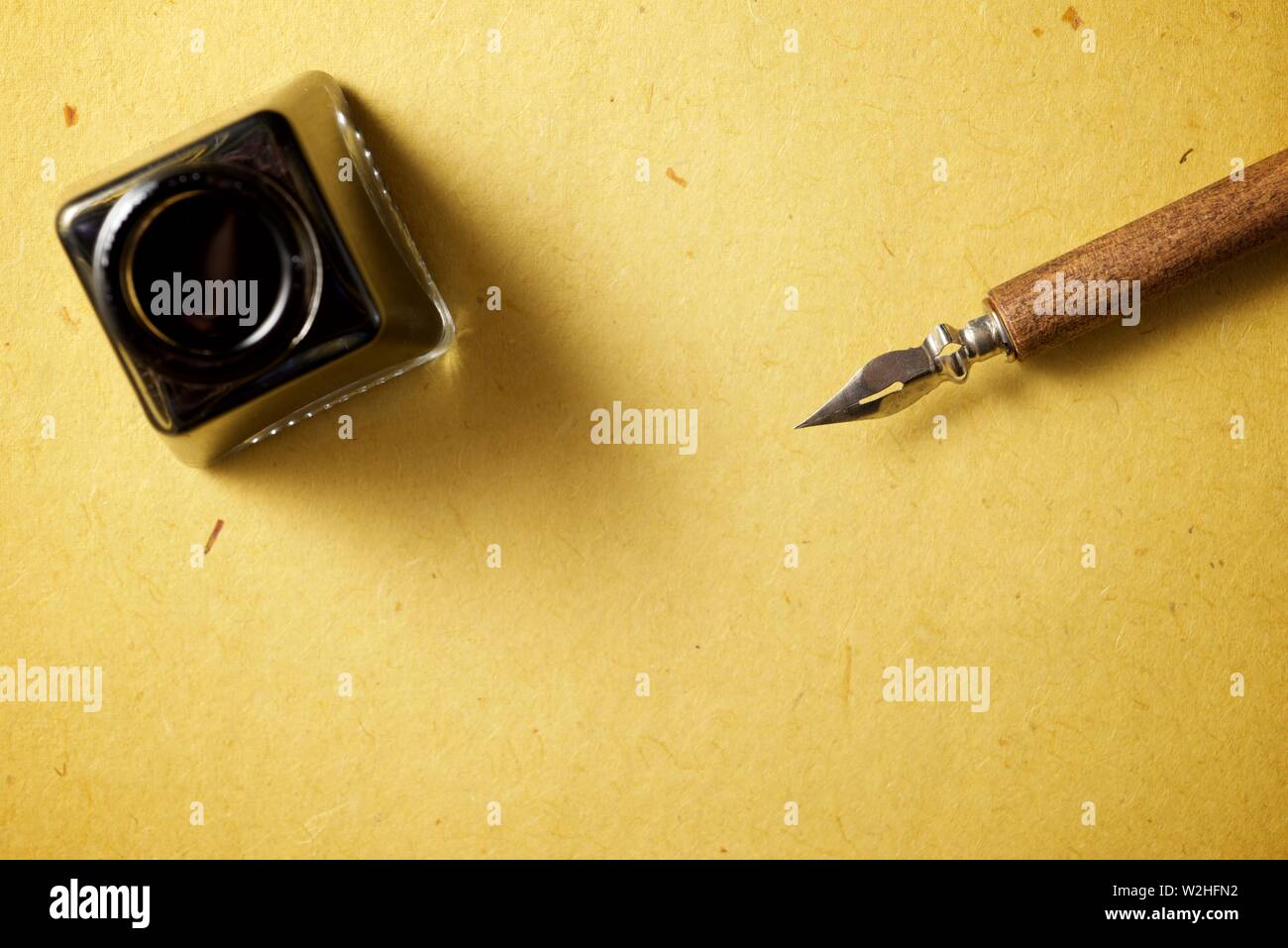 Nib pen for calligraphy and inkwell on a table Stock Photo - Alamy