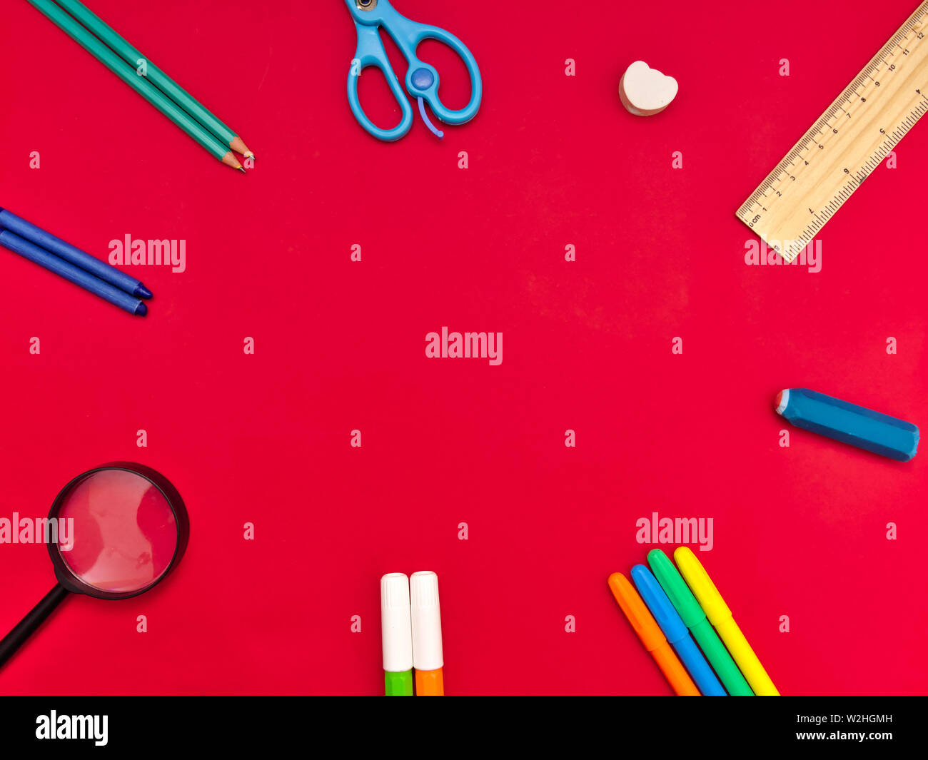 Colorful school supplies in circle arrangement on red background, back ...