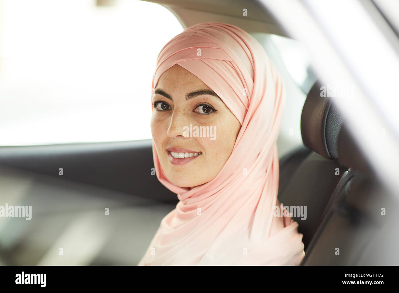 Portrait of positive young Arabian woman with freckles wearing pink ...
