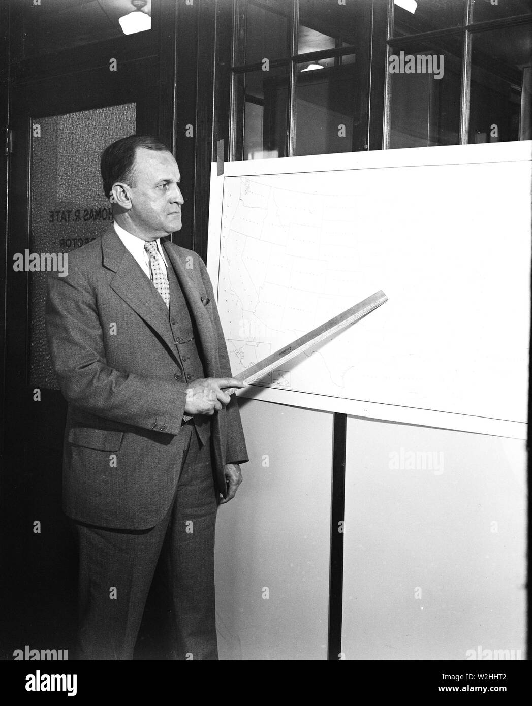 Man with ruler pointing at a map ca. 1934 Stock Photo - Alamy