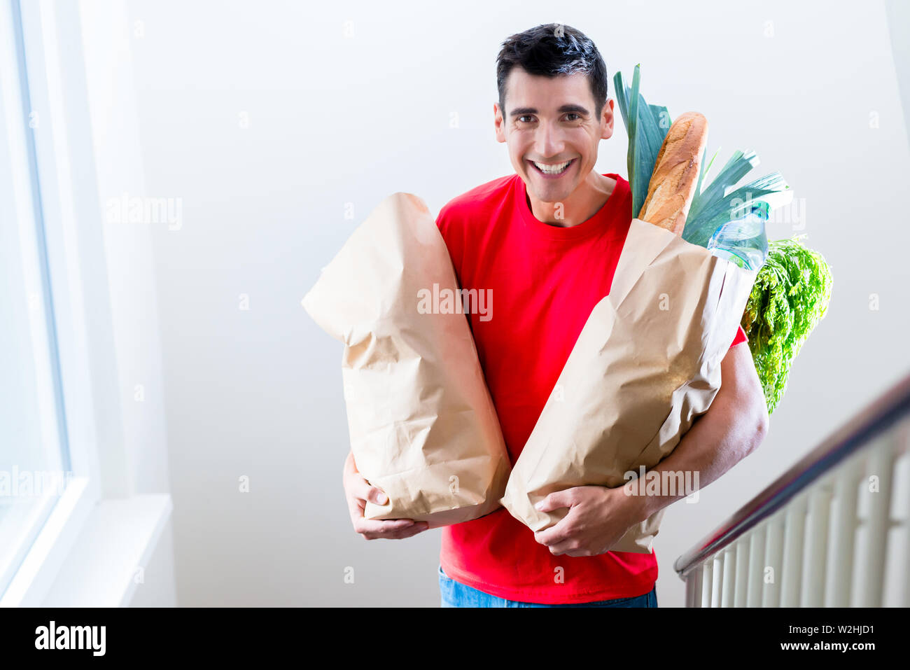 Delivery man delivering groceries Stock Photo - Alamy