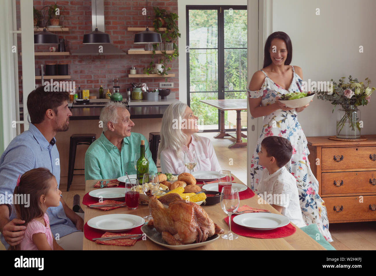 Multi-generation family having food on dining table at home Stock Photo ...