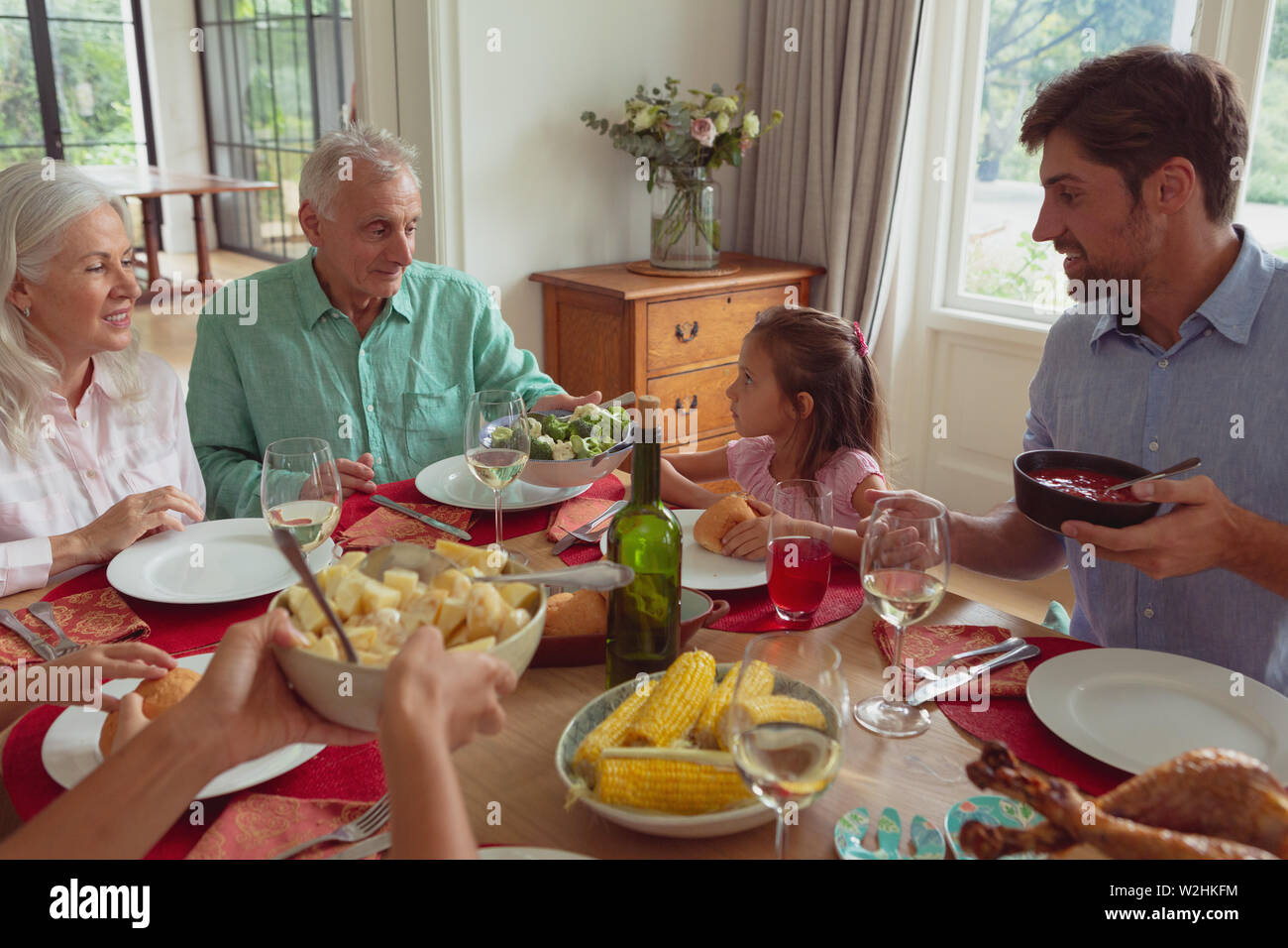 Multi-generation family having food on dining table at home Stock Photo ...