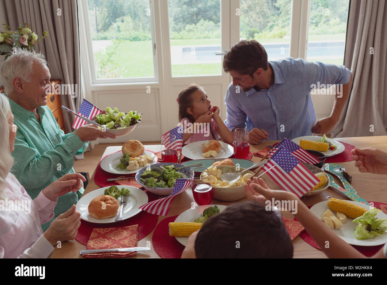 Multi-generation family having food on dining table at home Stock Photo ...